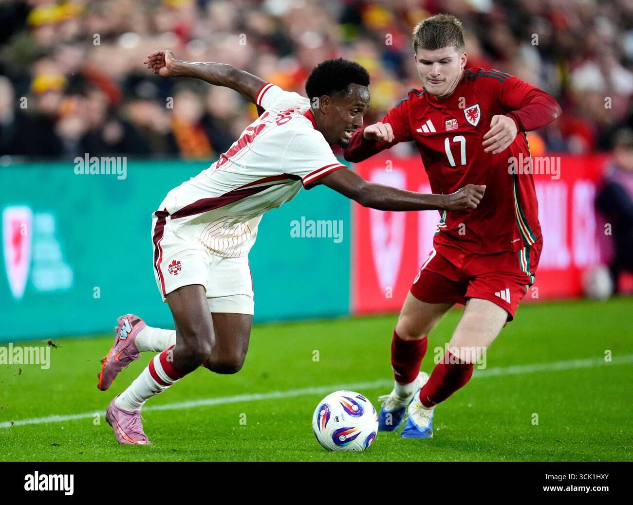 Canada's Ali Ahmed (left) and Wales' Jordan James battle for the ball ...