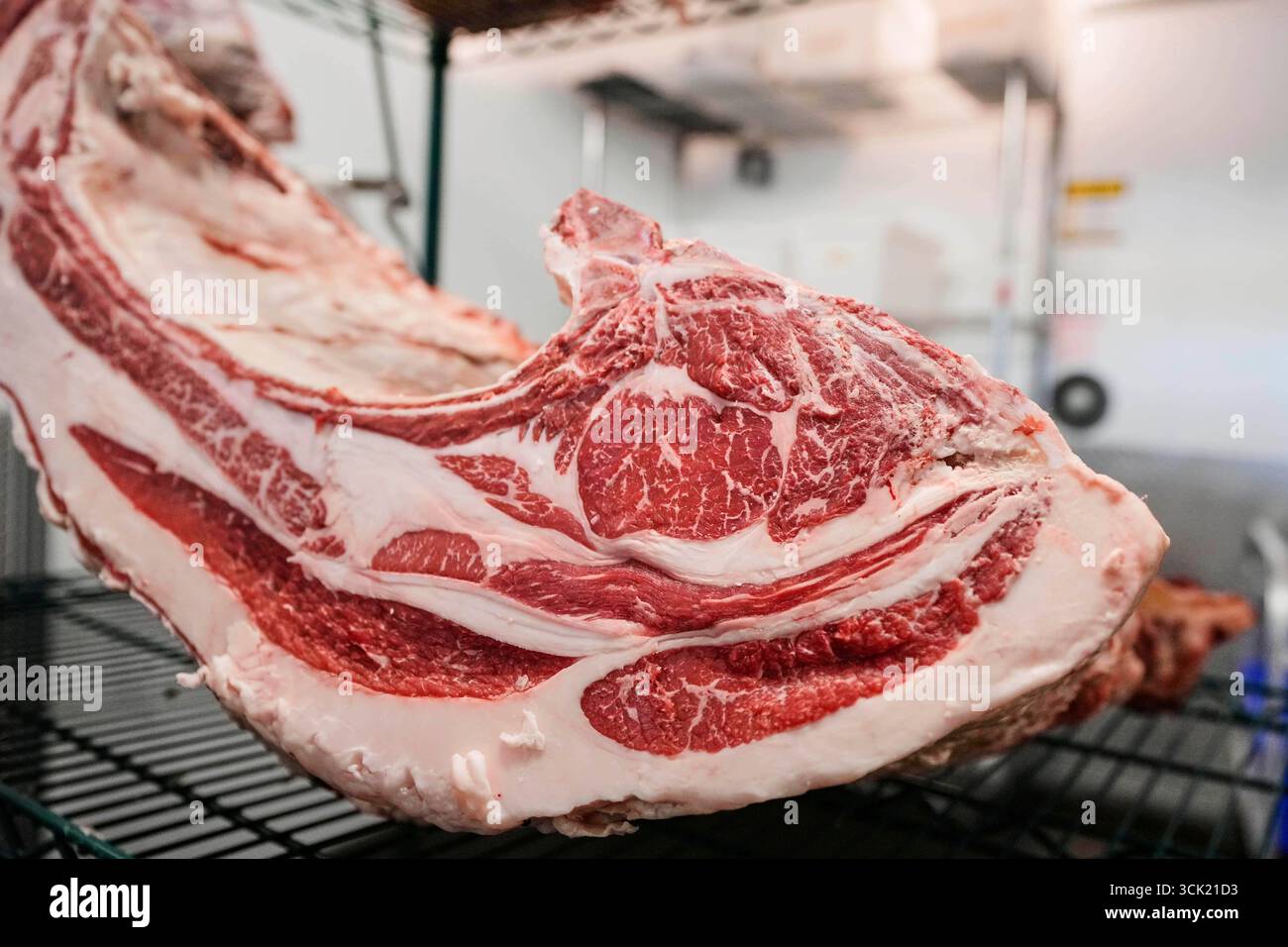Large primal cuts of beef sit on a rack in a cooler at Deep Cuts ...