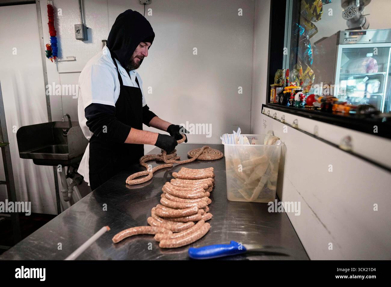 Dustin Price, a butcher at Deep Cuts butcher shop works on making maple ...