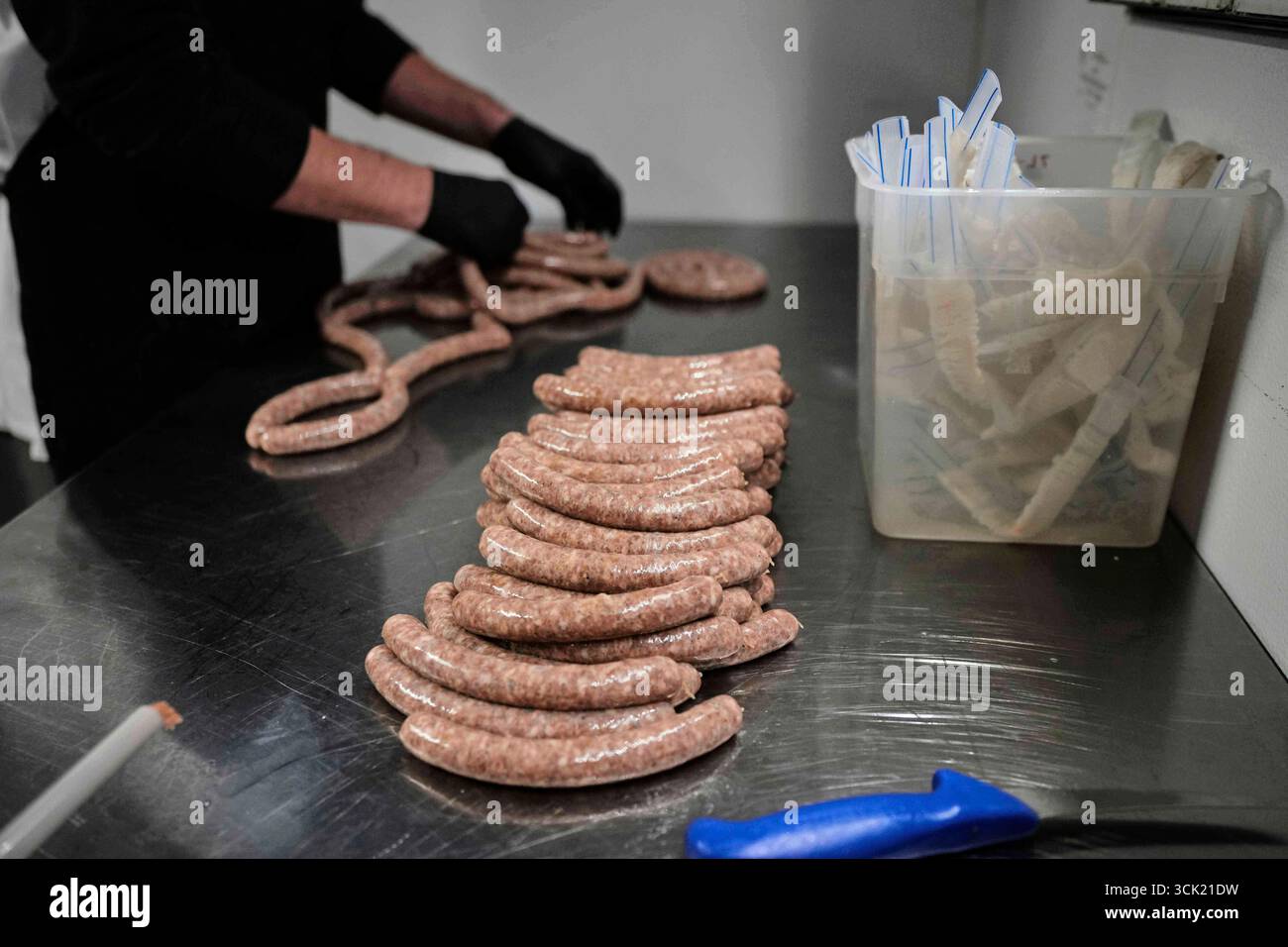 Dustin Price, a butcher at Deep Cuts butcher shop works on making maple ...