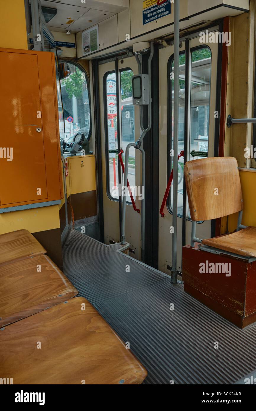 Vertical interior view of a vintage city tram with wooden seats, yellow ...