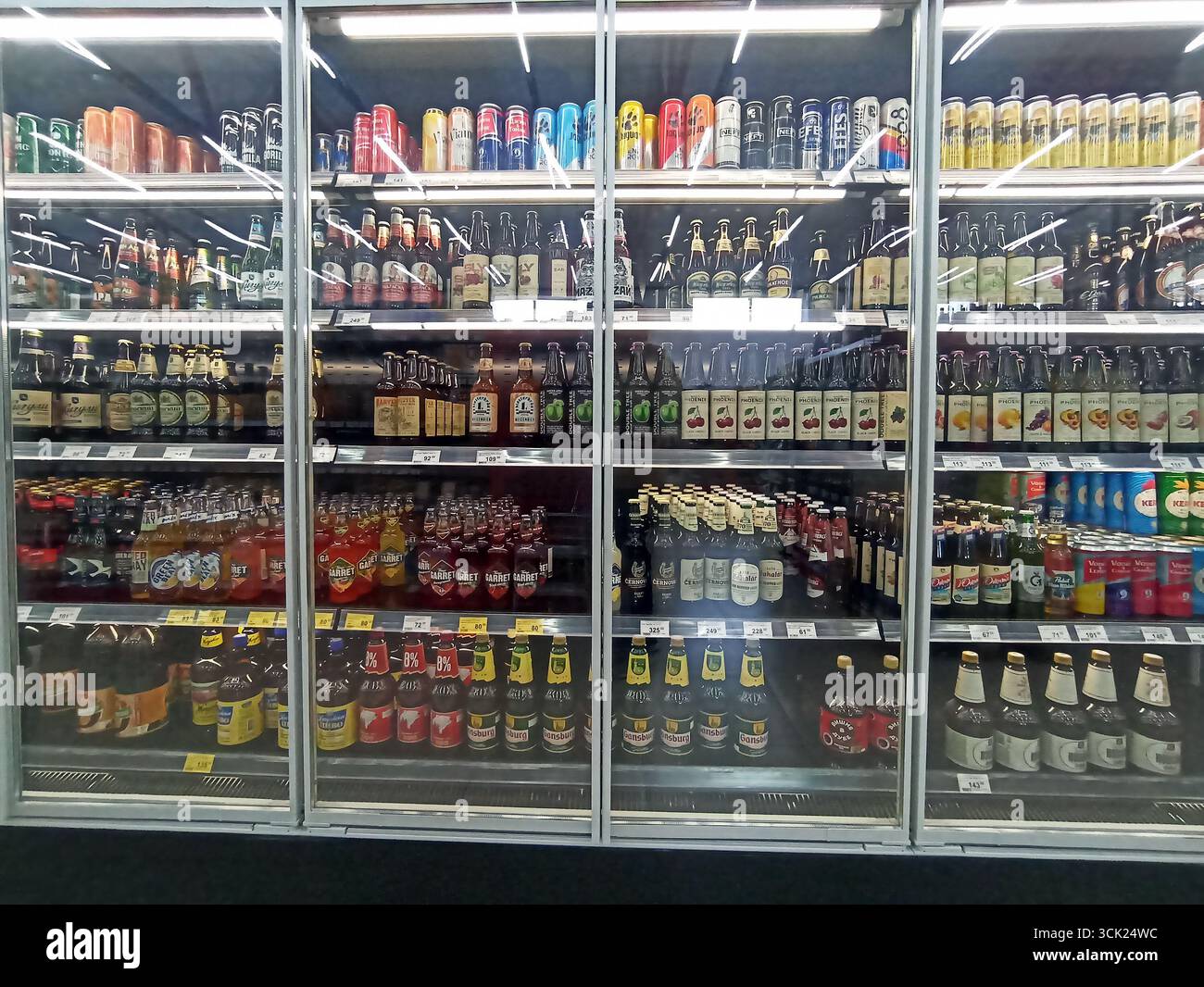 Wide selection of bottled beverages in refrigerator display at grocery ...