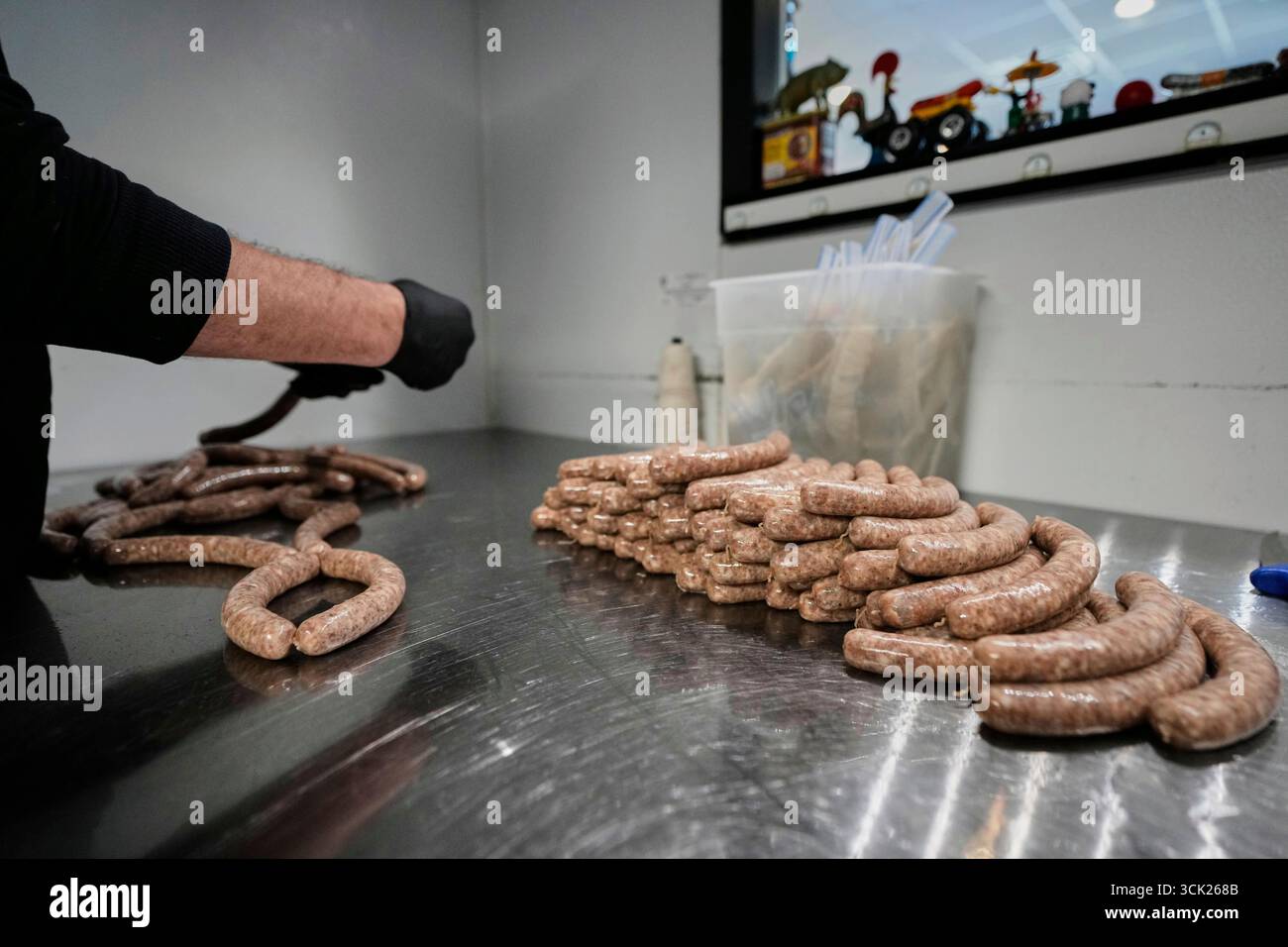 Dustin Price, a butcher at Deep Cuts butcher shop works on making maple ...