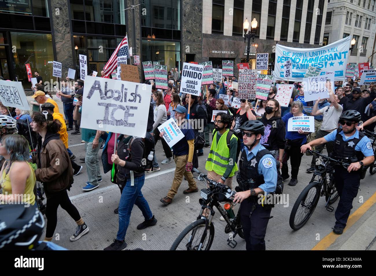 Demonstrators march at a protest opposing "Operation Midway Blitz" and ...