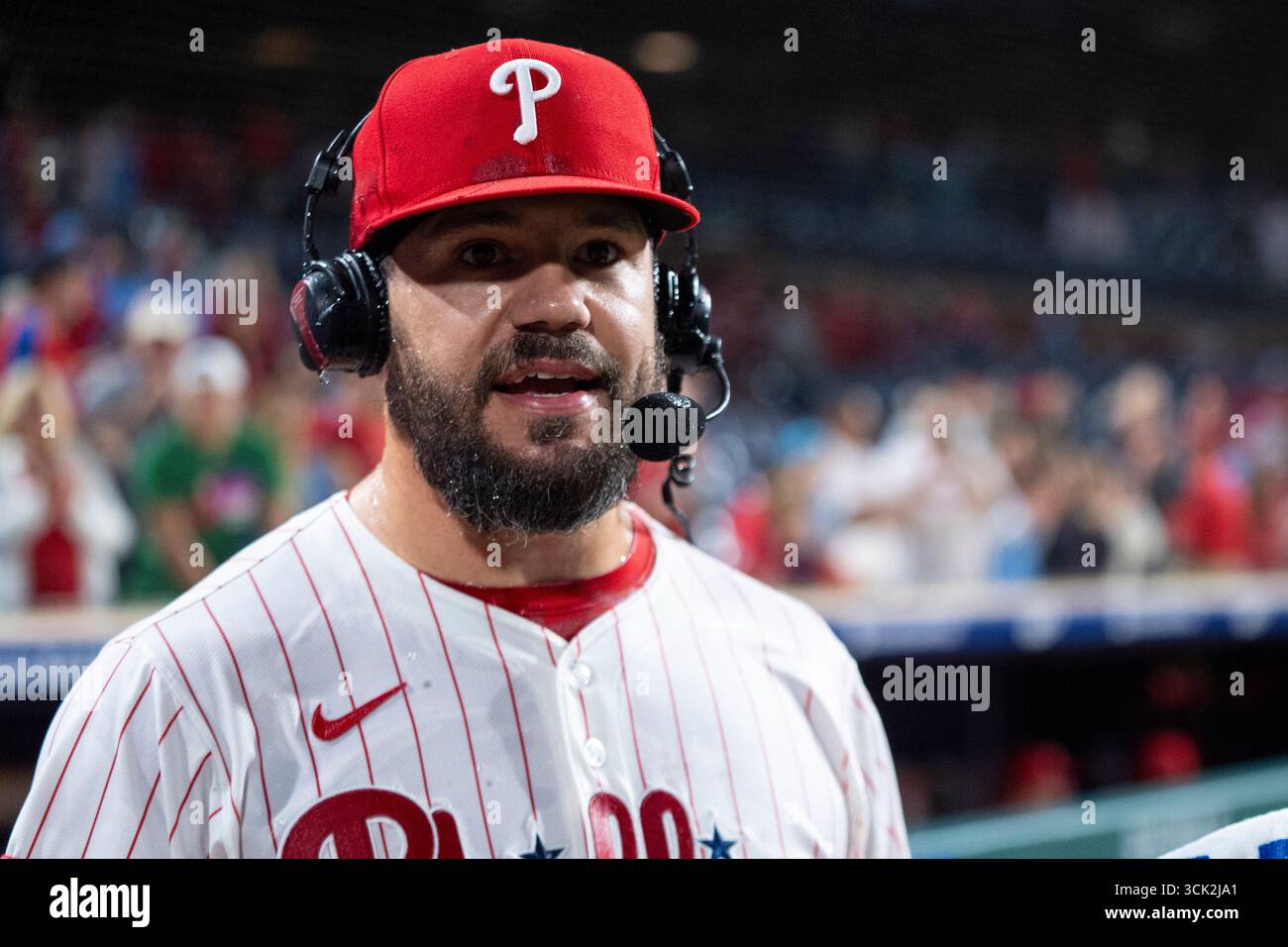 Philadelphia Phillies' Kyle Schwarber, looks on after getting doused with water as he is giving ...
