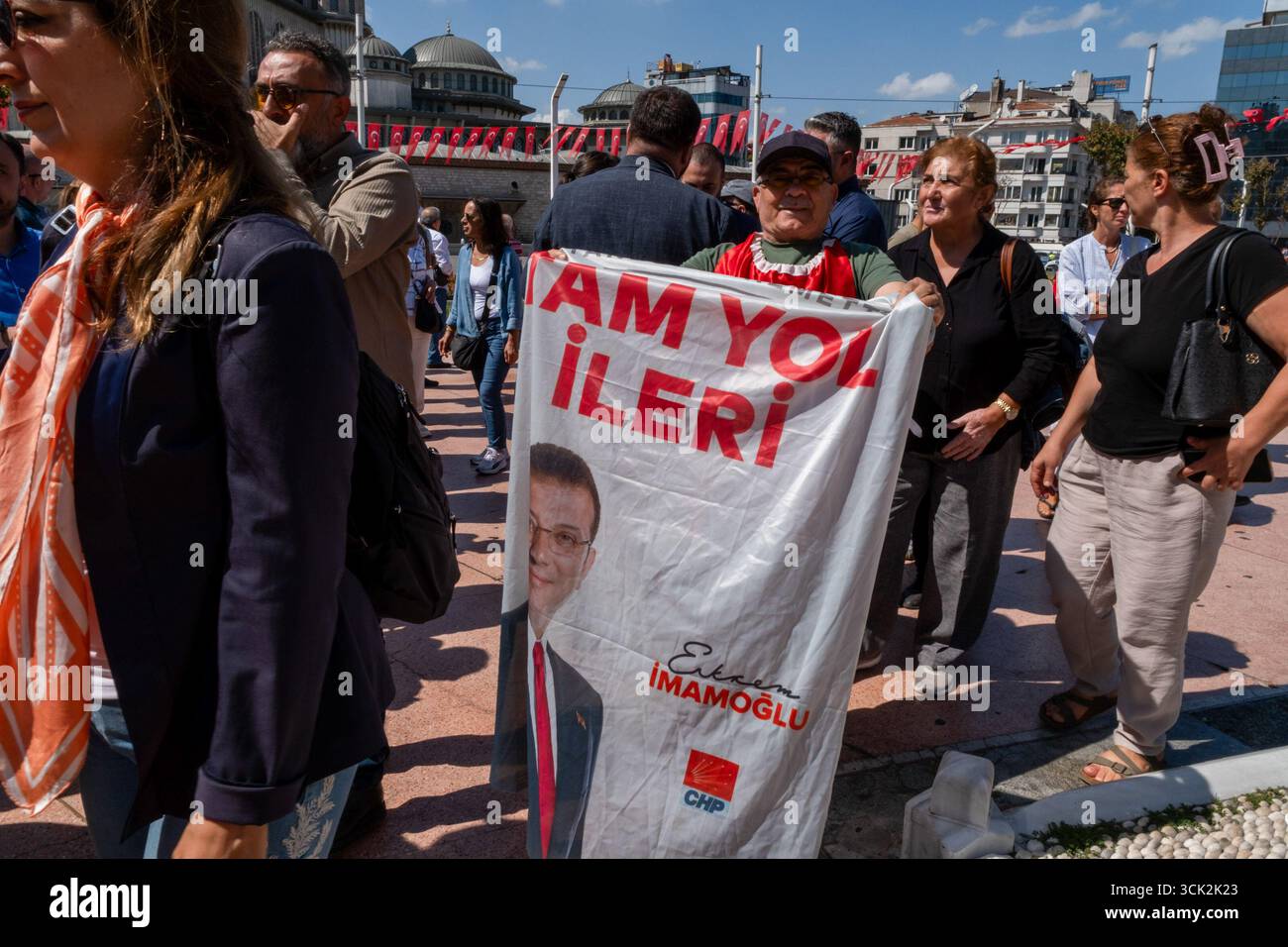 A man seen carrying a flag with a photo of Ekrem Imamoglu, the arrested mayor of Istanbul. A ...