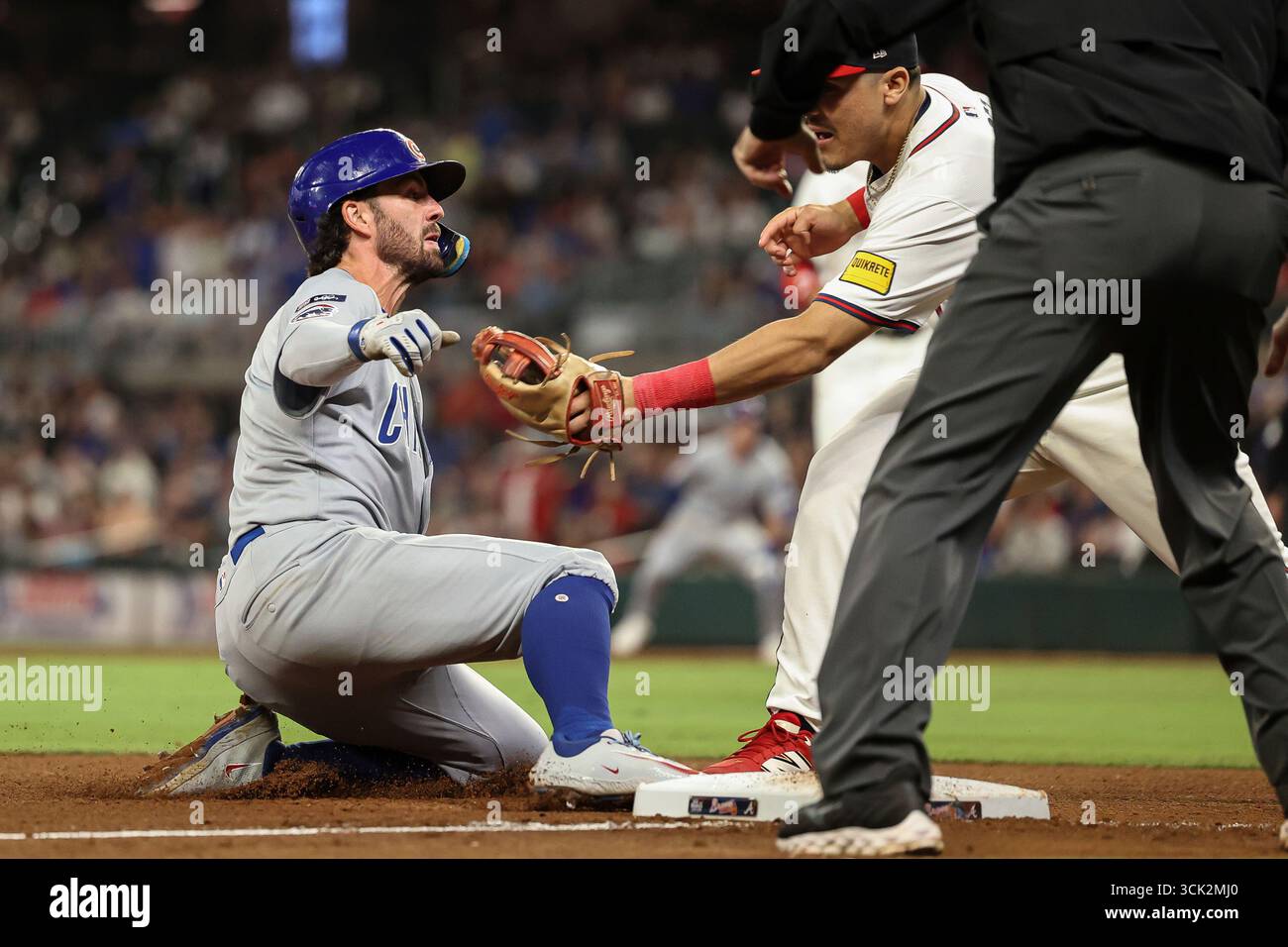 Chicago Cubs' Dansby Swanson, left, slides into third base in the ...
