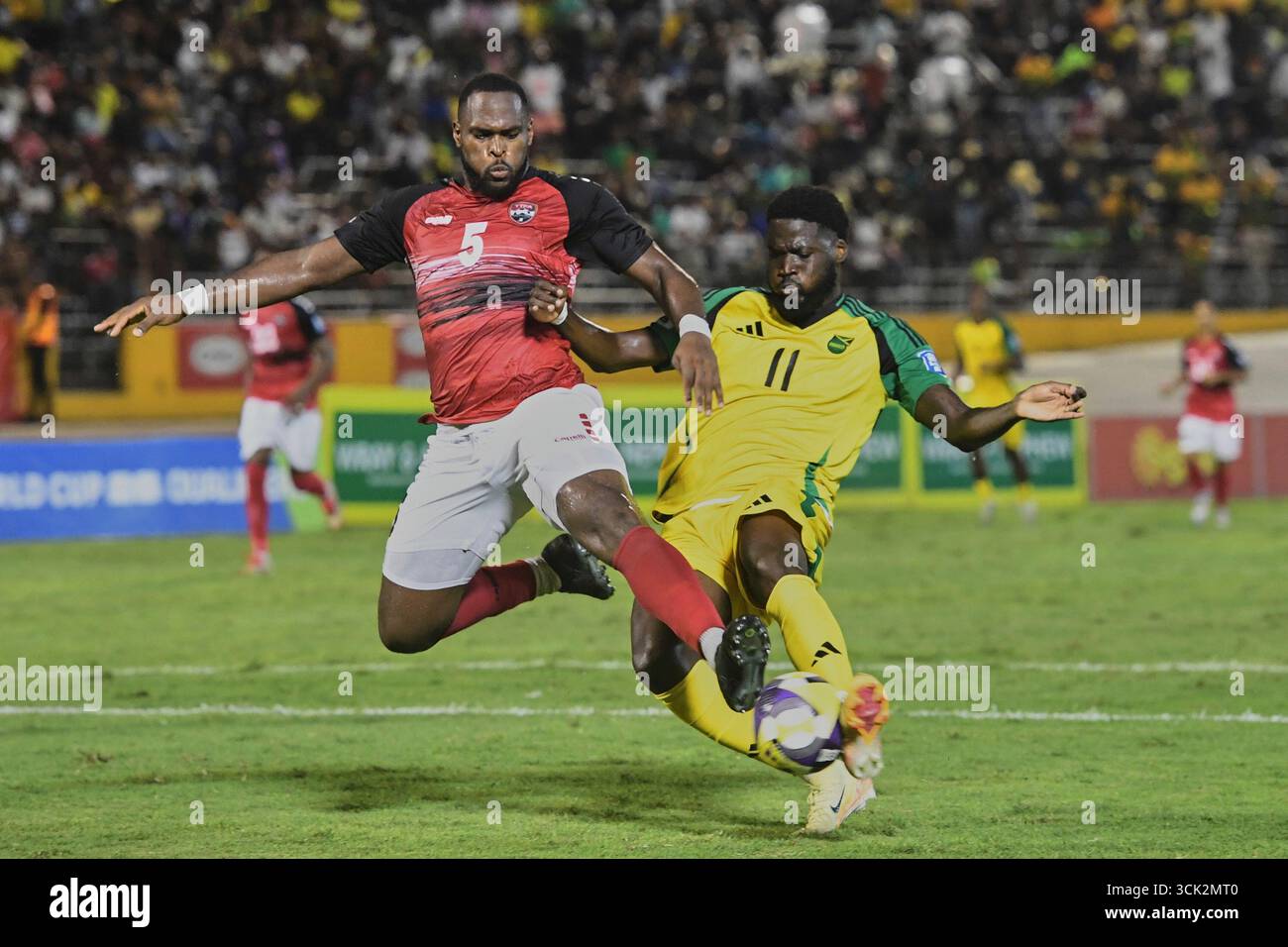 Trinidad and Tobago's Josiah Trimmingham, left, tackles Jamaica's ...