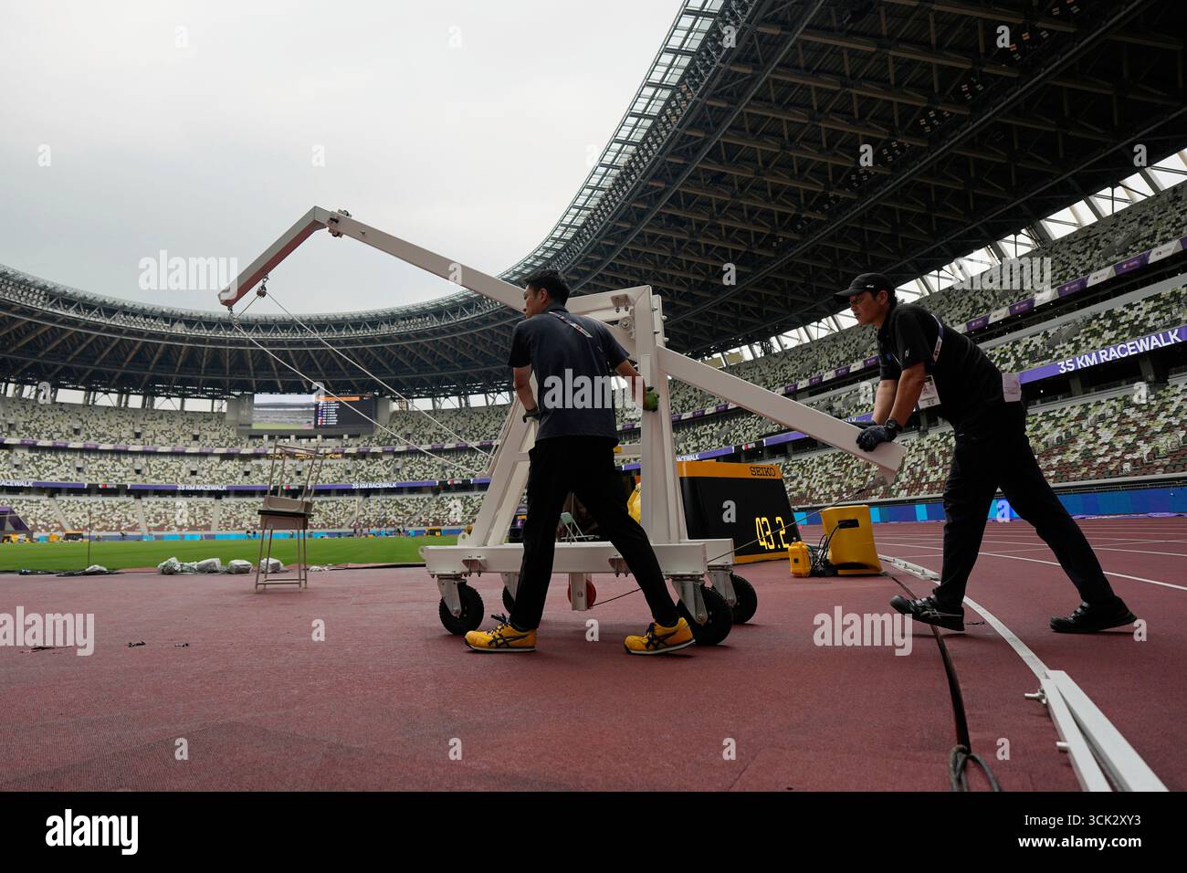 Workers set up the cage for hammer throw and discus for the World ...