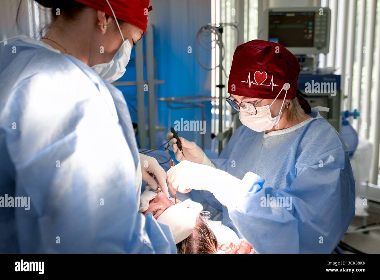 Medical professionals wearing protective surgical attire conduct a ...