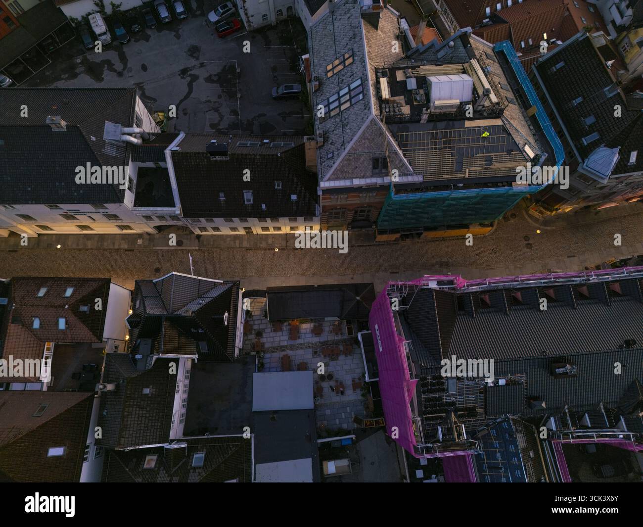 Aerial view of rooftops and streets interweave under the soft glow of ...