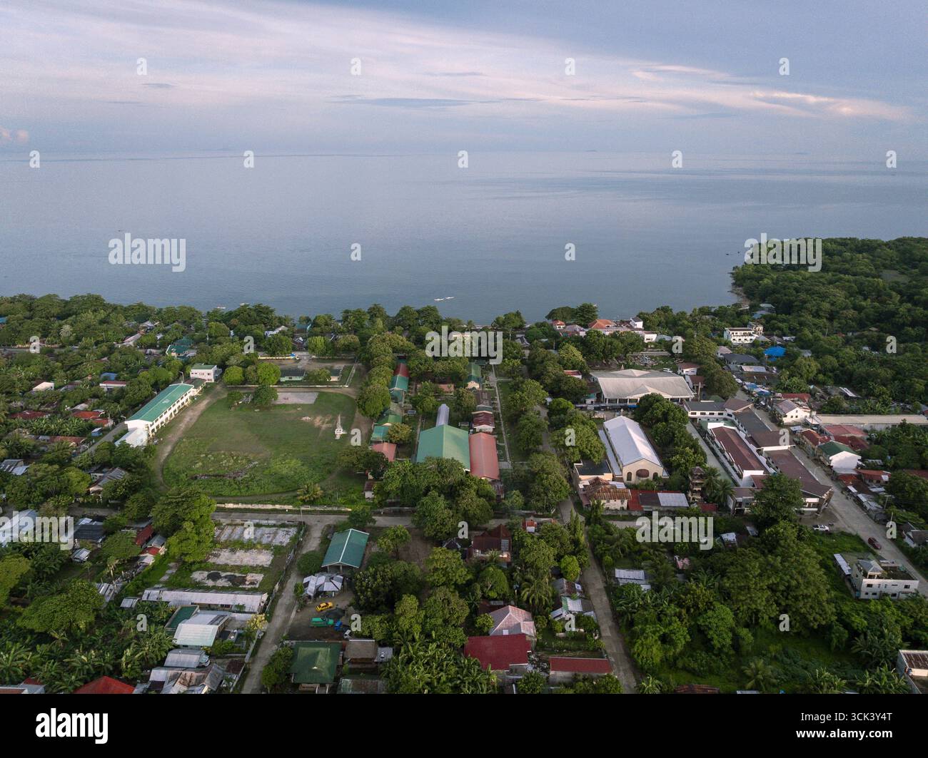 Aerial view of a tranquil town nestled between lush greenery and the ...