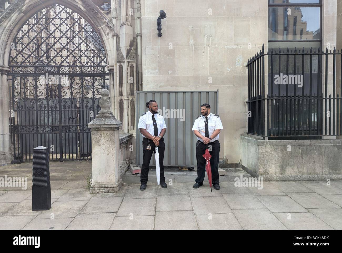 Security guards by the new artwork by Banksy which shows a judge ...