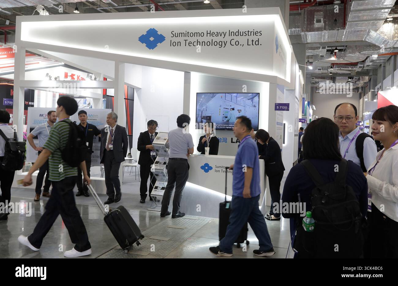 Visitors walk by Sumitomo Corporation booth during the SEMICON Taiwan ...