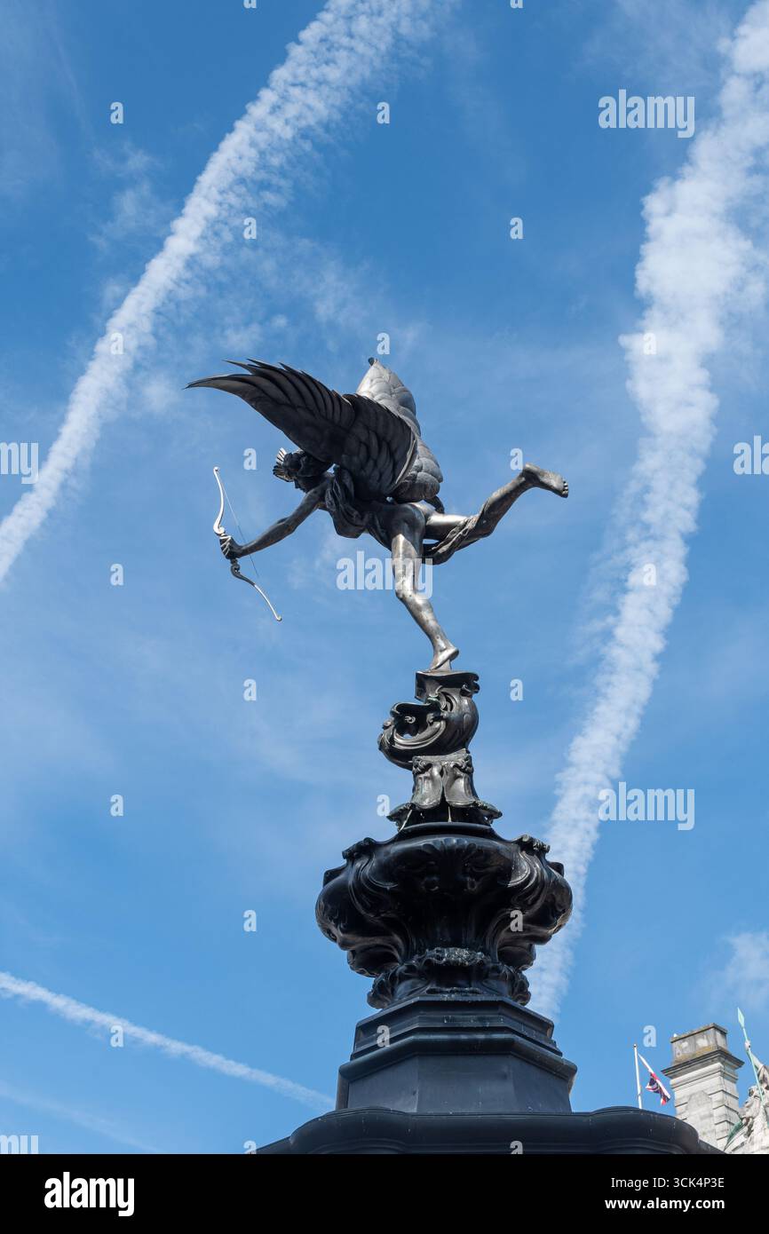 Statue surrounded by airplane contrails in blue sky hi-res stock ...