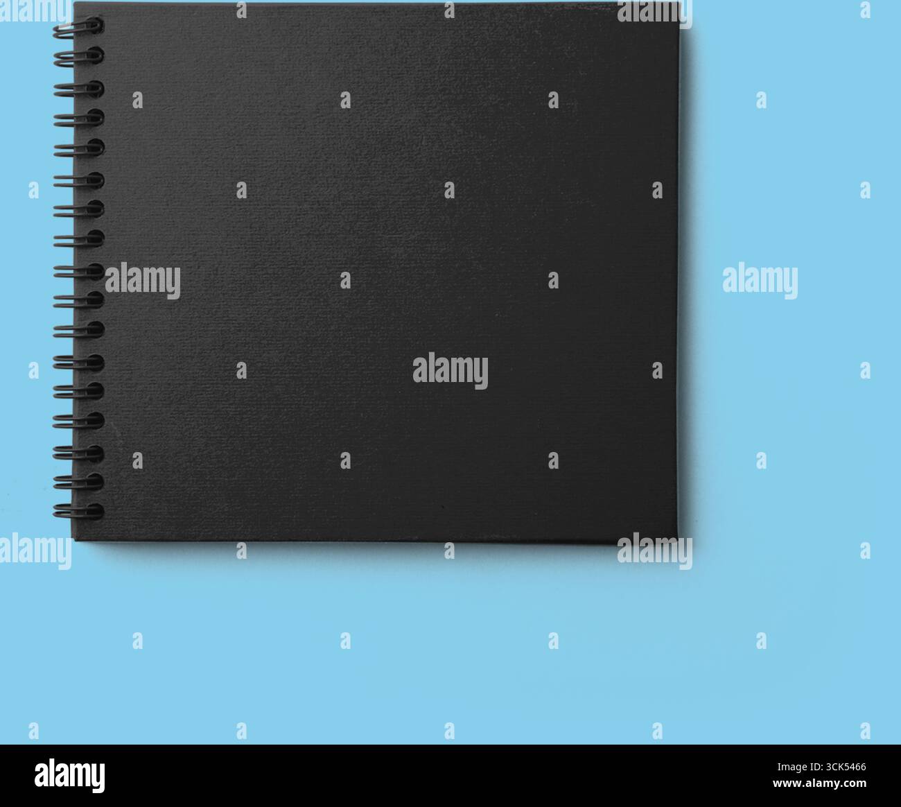 A plain black spiral notebook, ideal for sketching, note-taking, or ...