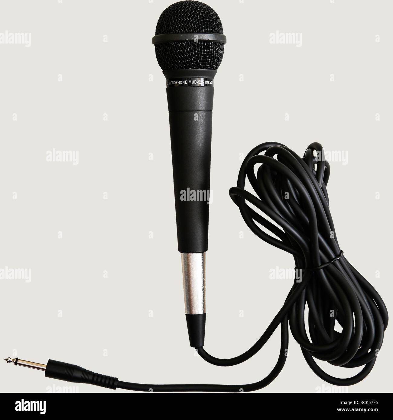 A black microphone with a coiled cable, commonly used for audio ...