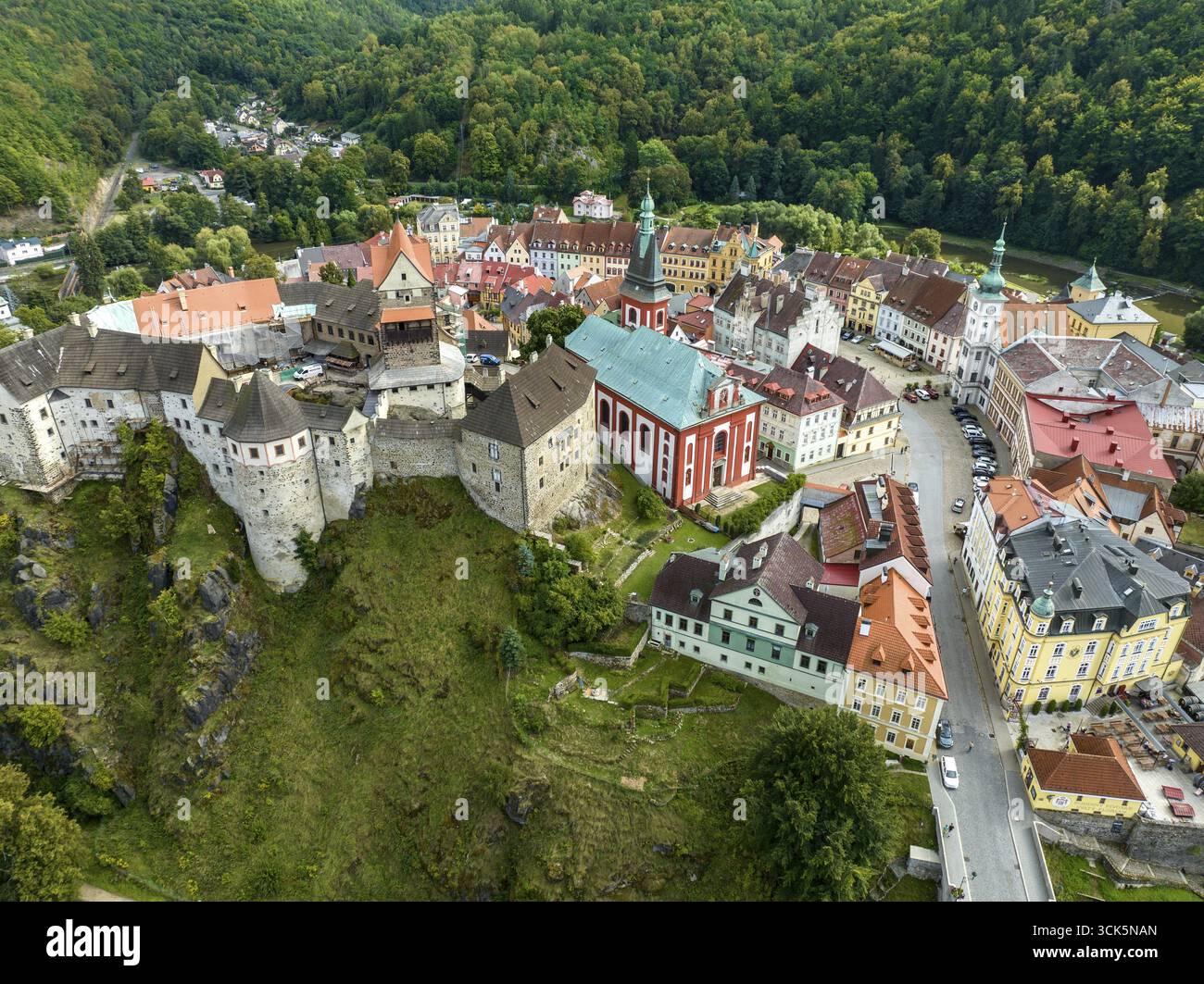 Impressive castle on a green hill, surrounded by a colourful town with ...