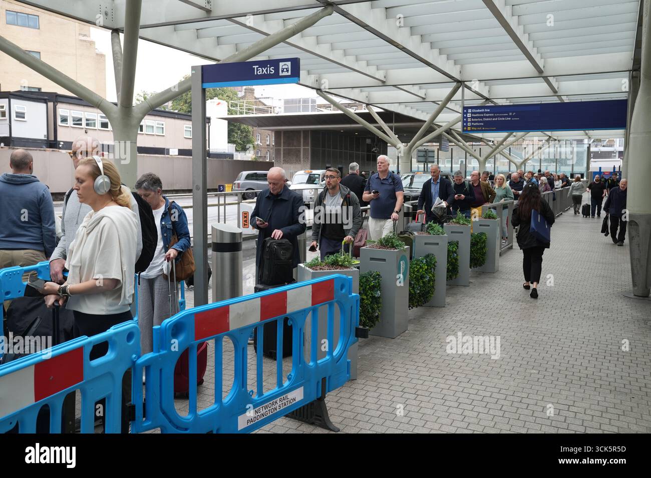 People queue for taxis outside Paddington Station, London, on the third ...