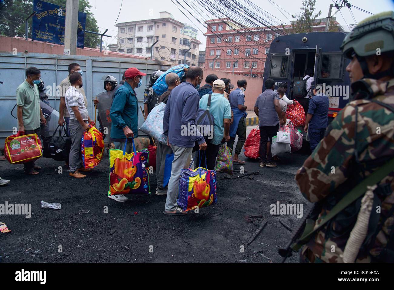 Prisoners carrying their belongings are transferred to another jail ...
