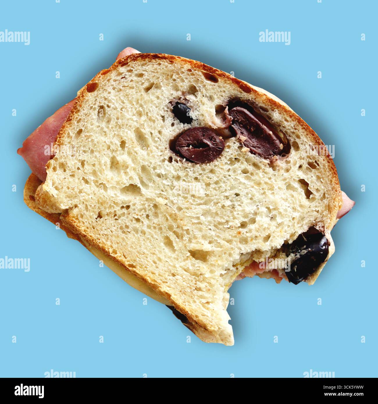 A slice of bread with a bite taken out, featuring visible olives and ...