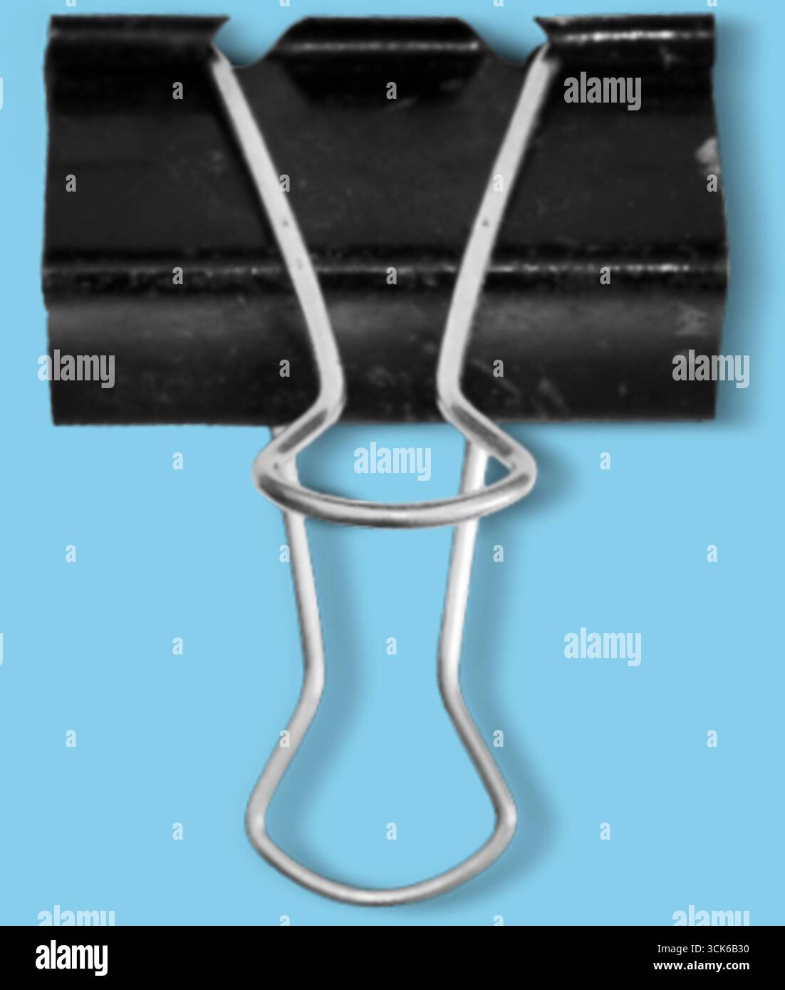 A black binder clip used for holding multiple sheets of paper together ...