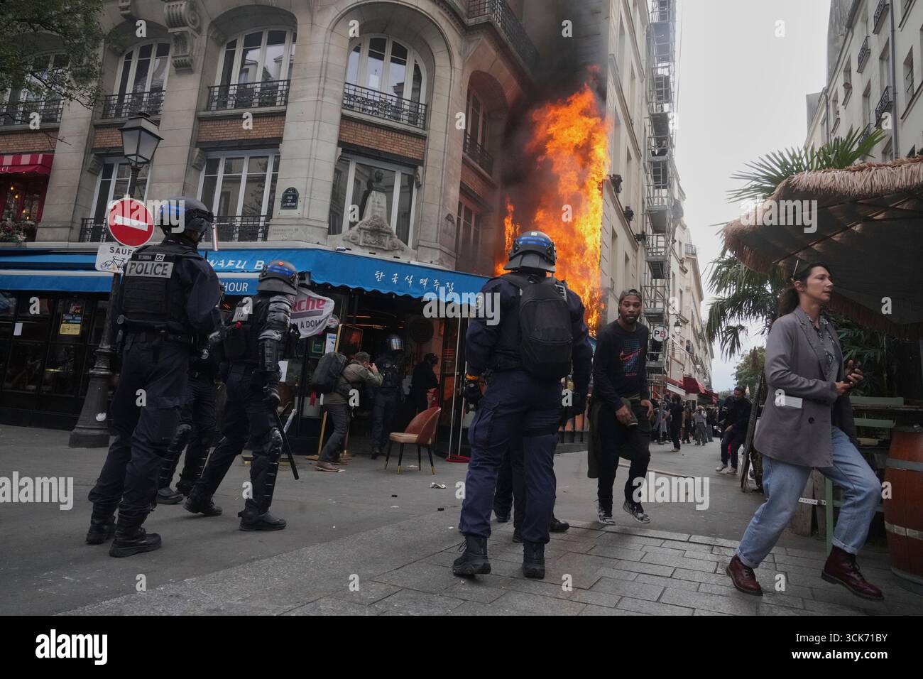 Riot police officers take position in front of a burning restaurant ...