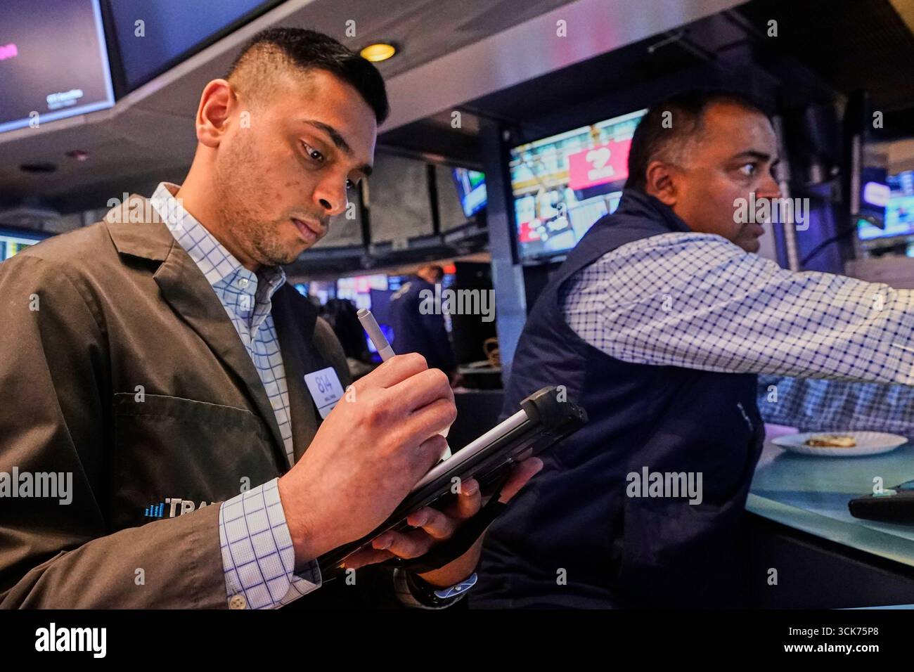Trader Niall Pawa, left, and specialist Dilip Patel work on the floor ...