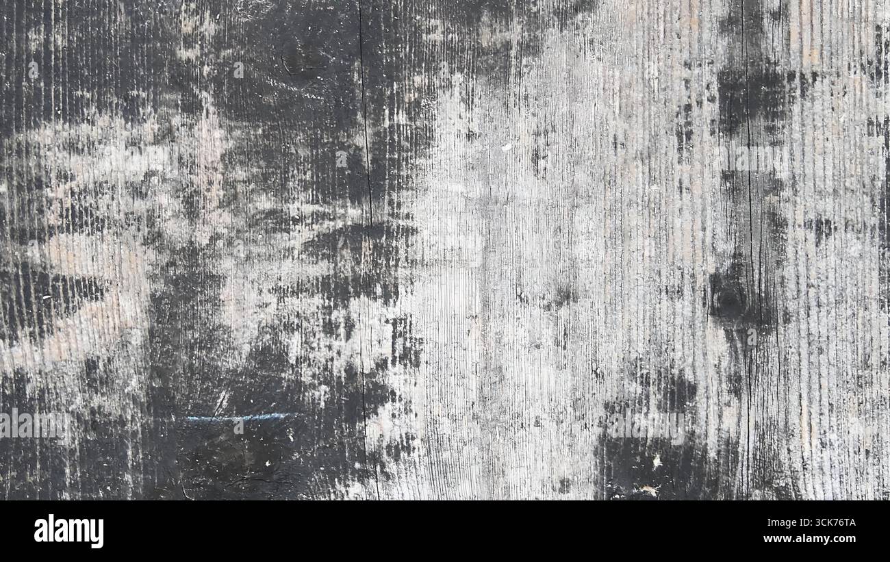 A textured surface with a weathered, dark appearance, featuring ...