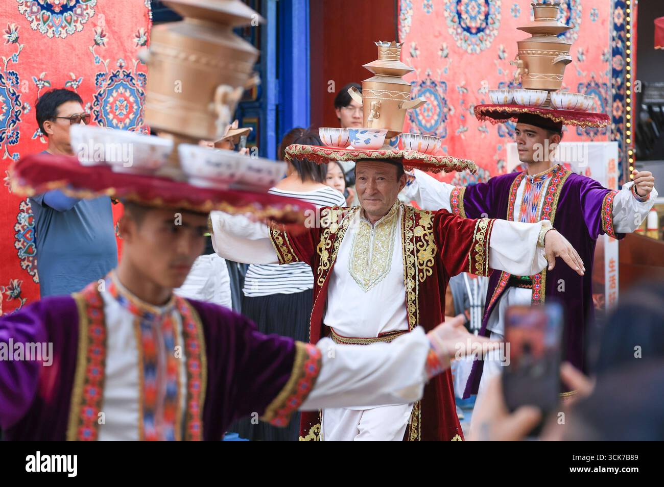 (250910) -- URUMQI, Sept. 10, 2025 (Xinhua) -- Parhat Emin (C) performs ...