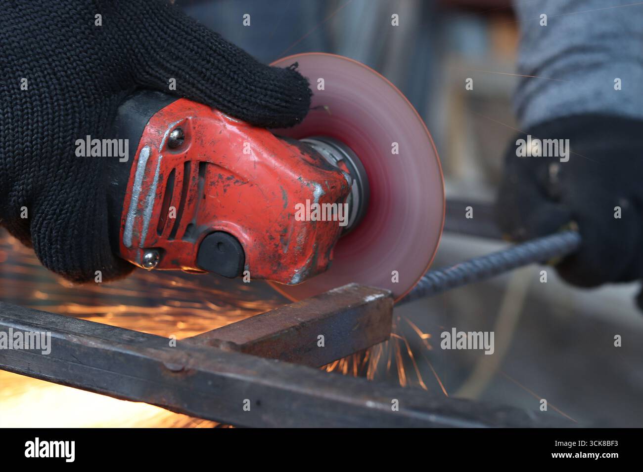 Angle grinder cutting rebar, sparks flying. Angle grinder with metal ...