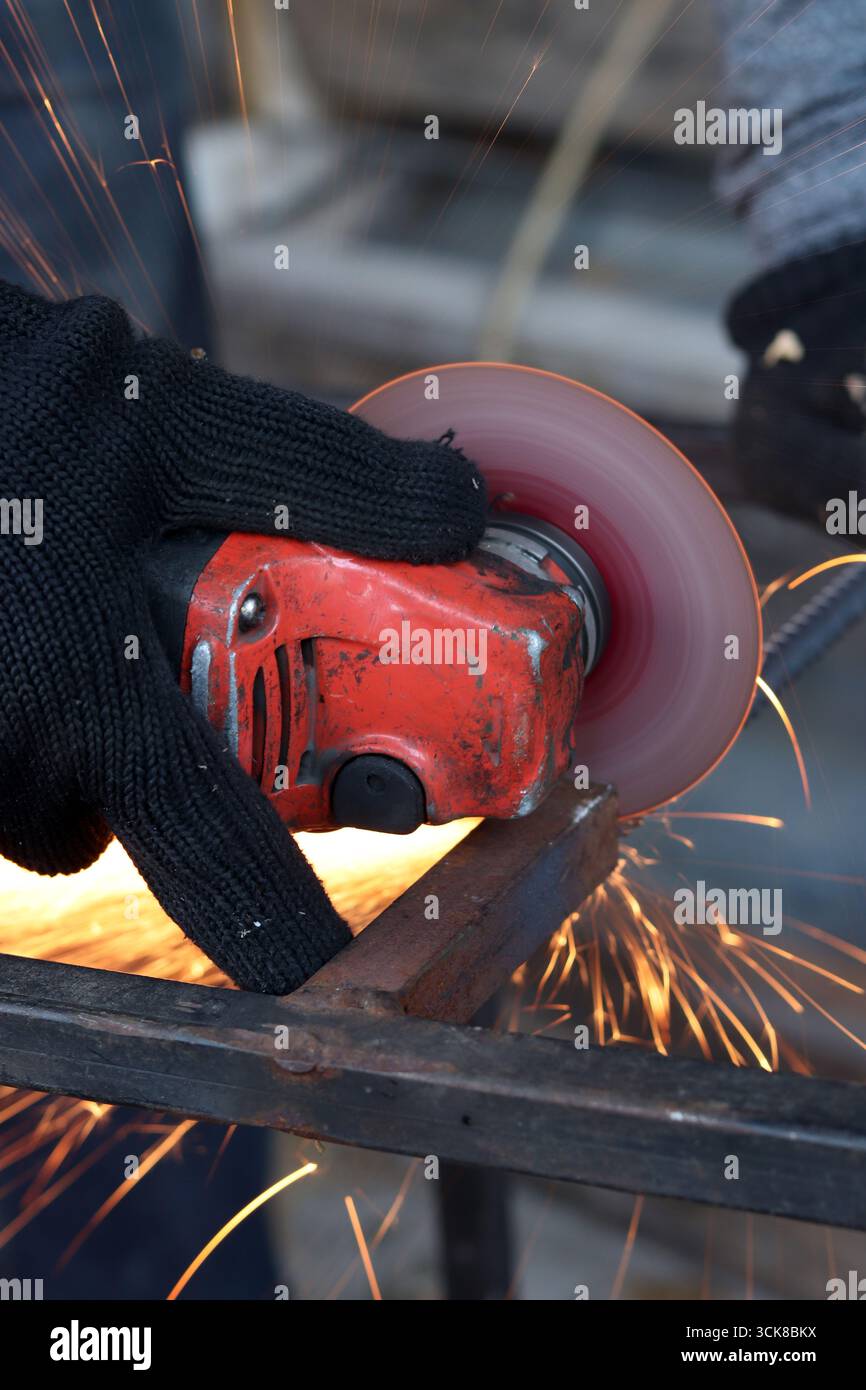 Angle grinder cutting rebar, sparks flying. Angle grinder with metal ...