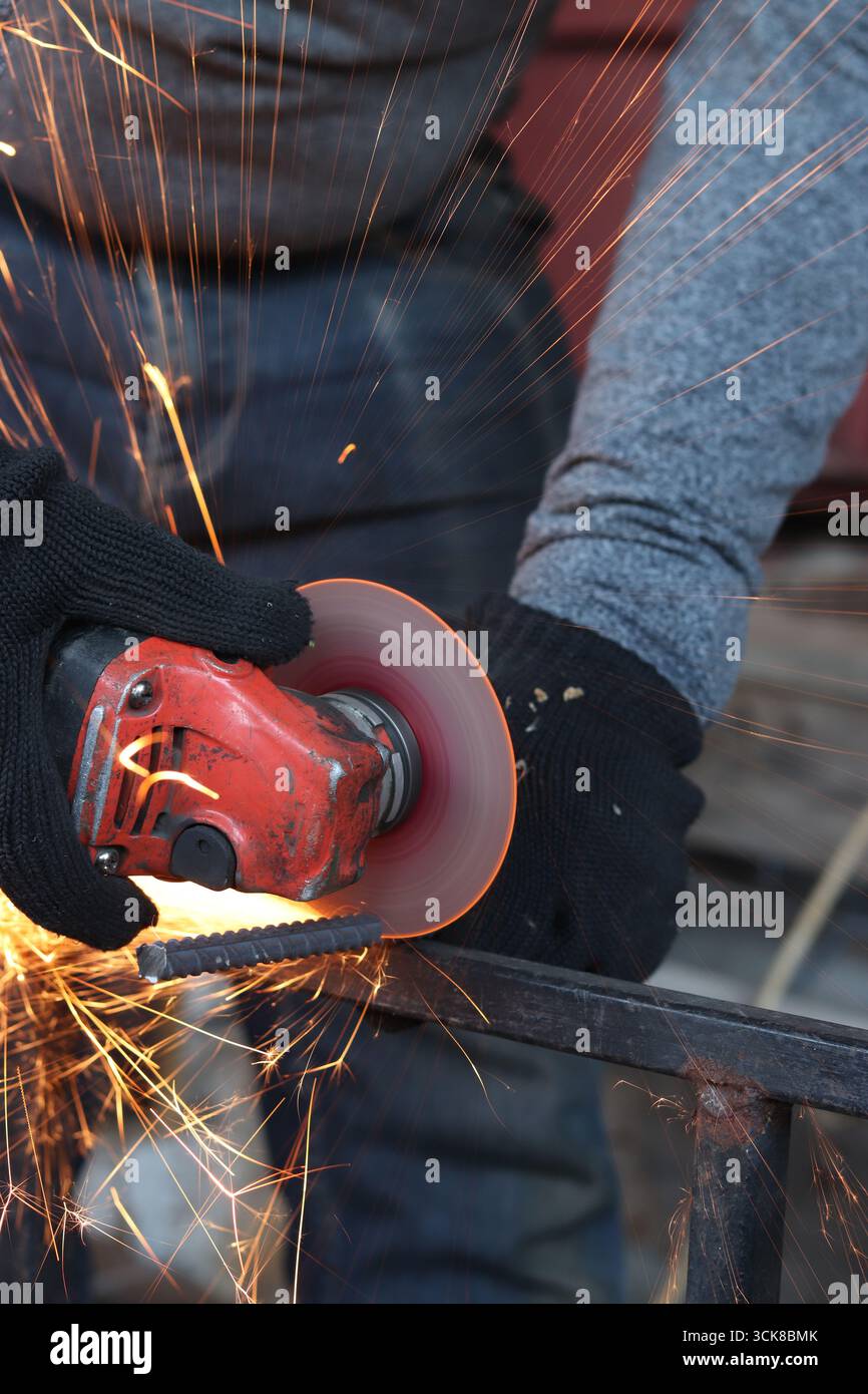 Angle grinder cutting rebar, sparks flying. Angle grinder with metal ...