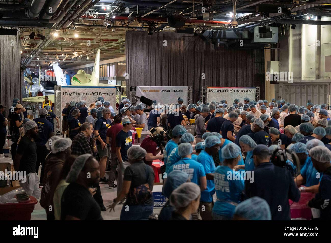 Volunteers work during the "NYC Meal Pack For 9/11 Day" at the Intrepid ...