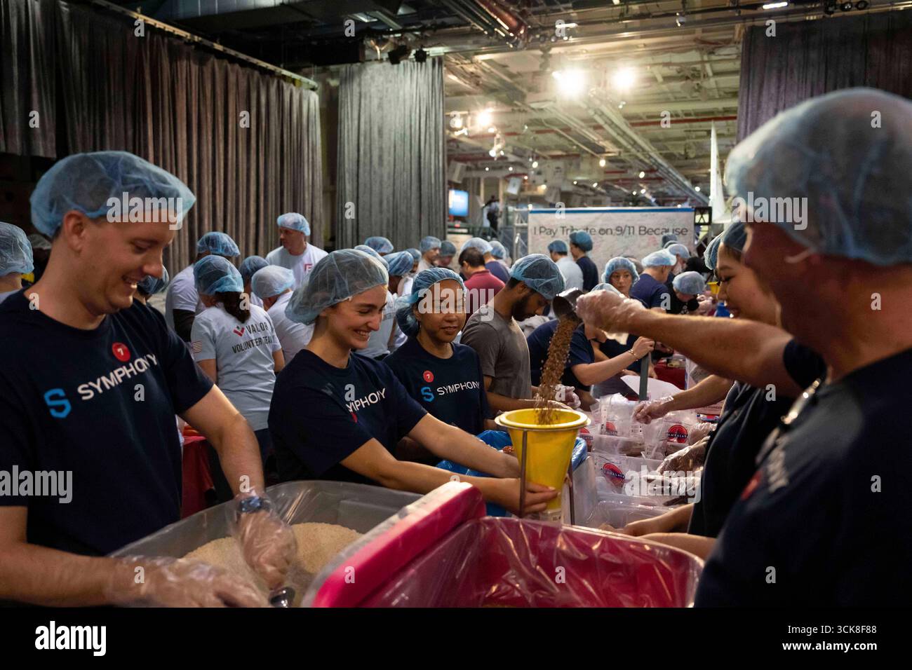 Volunteers work during the "NYC Meal Pack For 9/11 Day" at the Intrepid ...