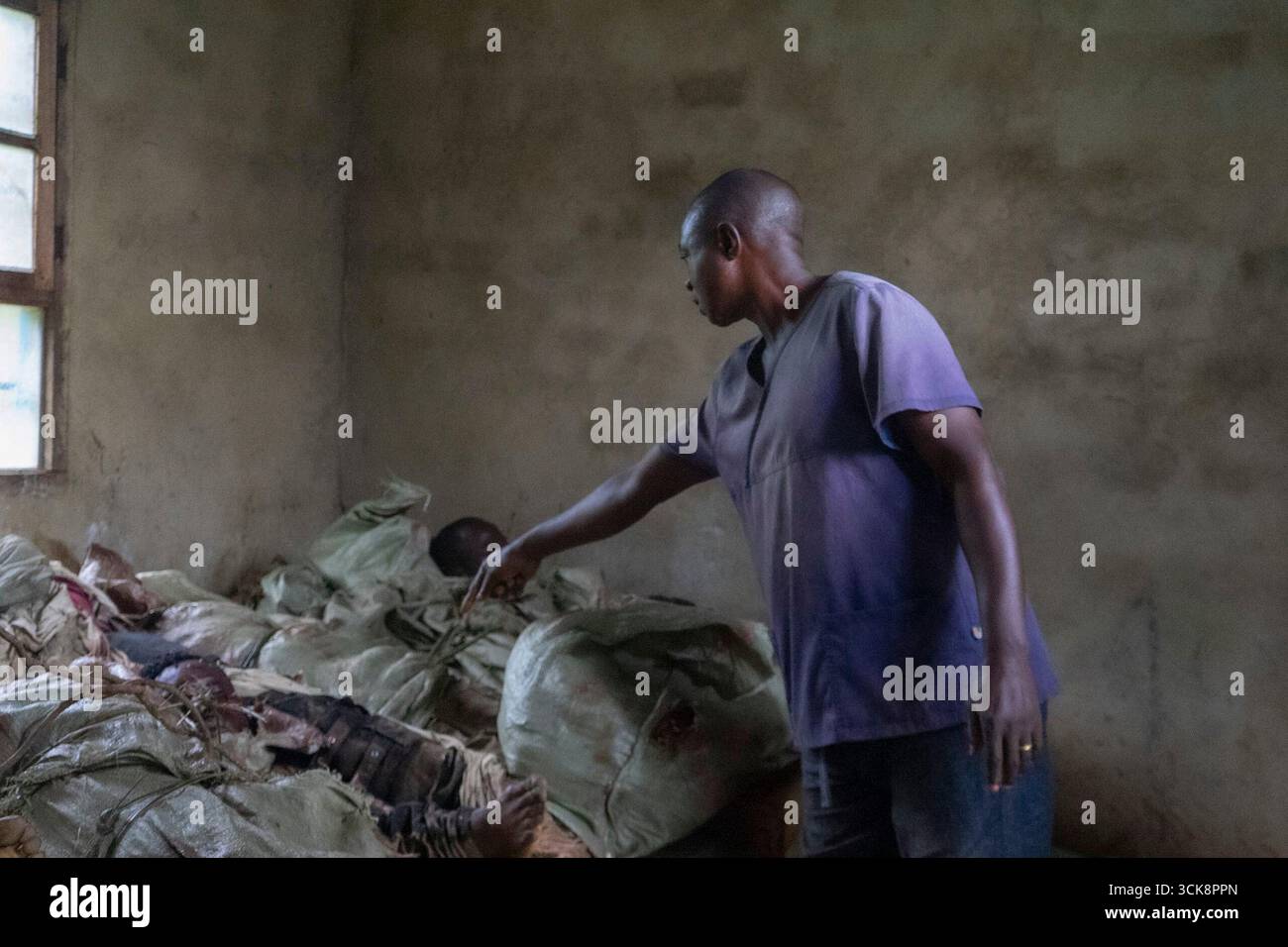 A morgue worker points to bodies of people killed during an attack in ...