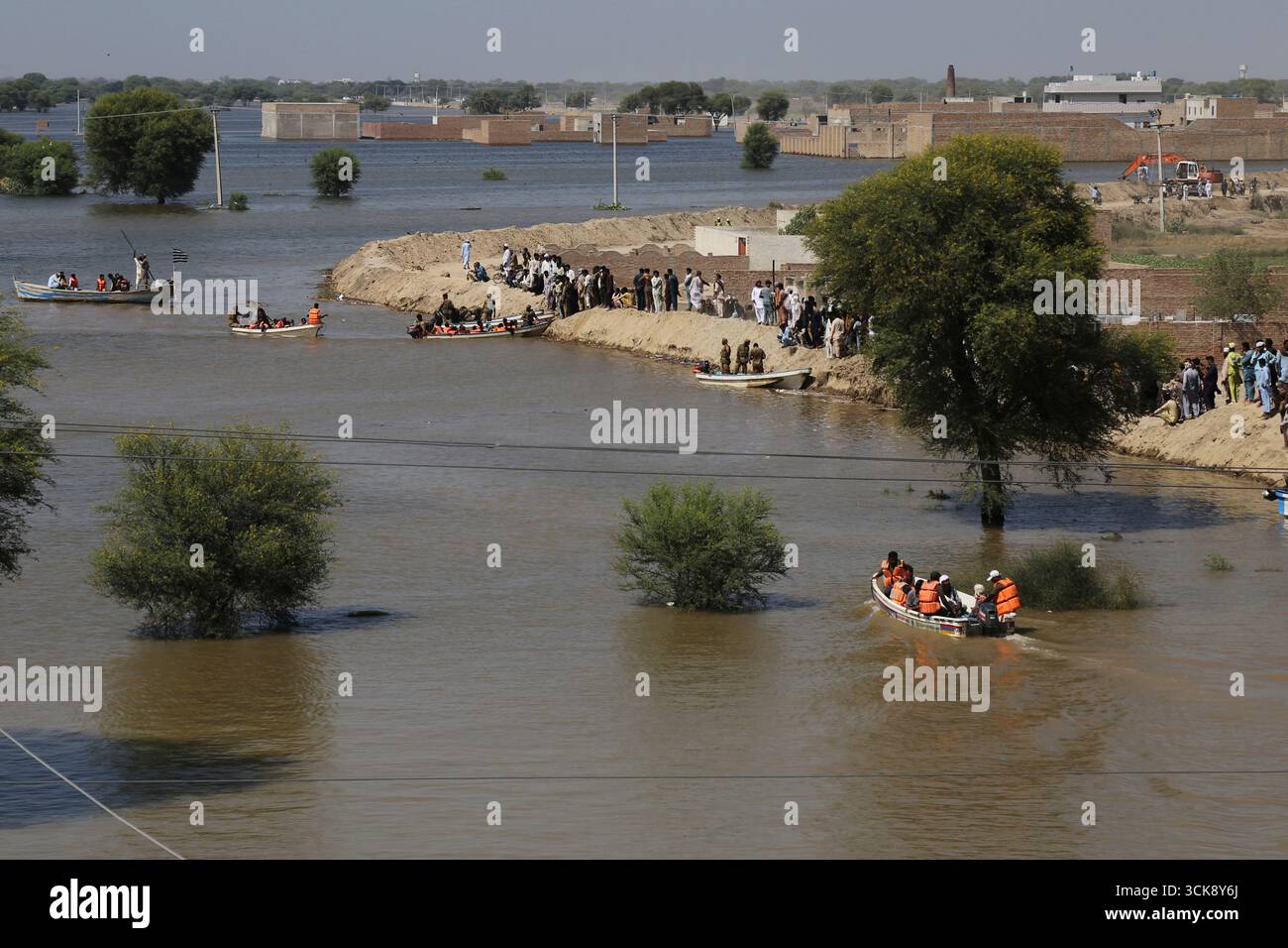 Rescue workers evacuate villagers from a flooded area in Jalalpur Pirwala, in Multan district ...