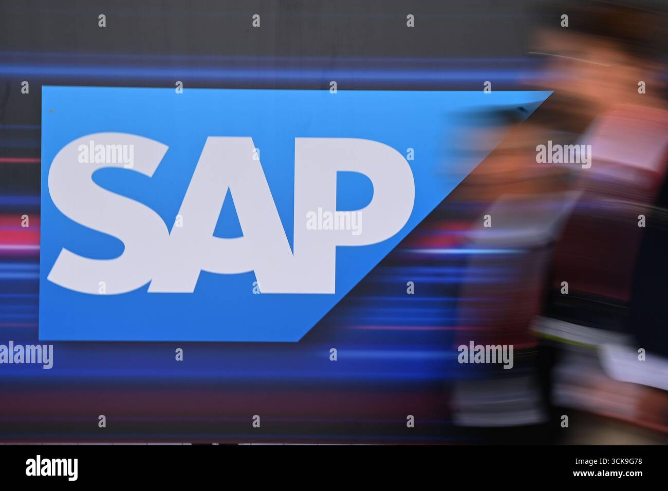 People in front of the SAP logo, company logo, brand emblem, brand logo ...