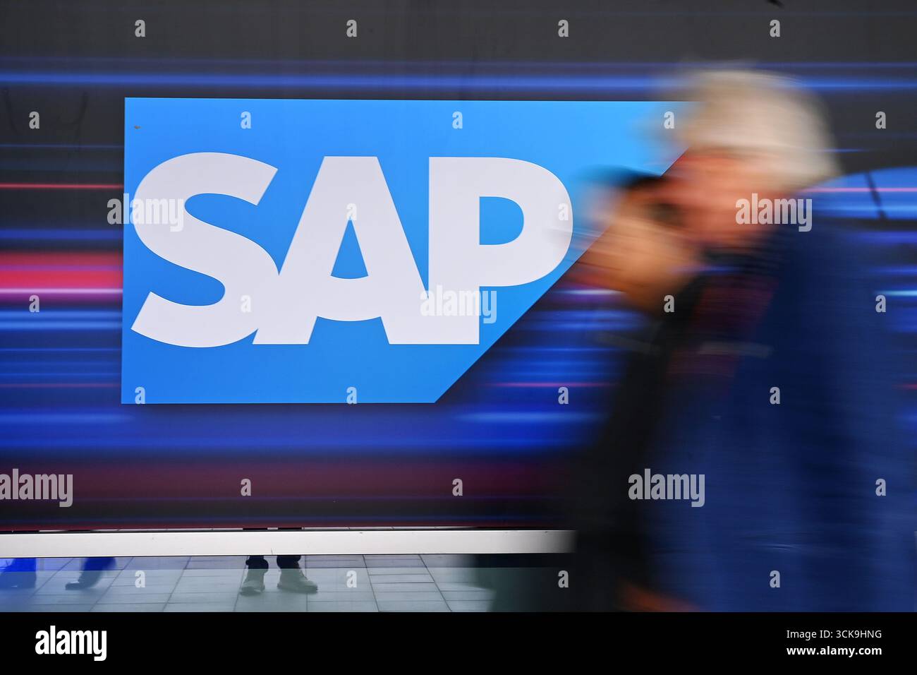 People in front of the SAP logo, company logo, brand emblem, brand logo ...