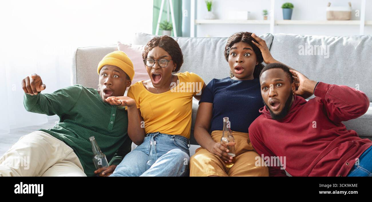 Shocked african american friends watching horror movie, sitting on ...