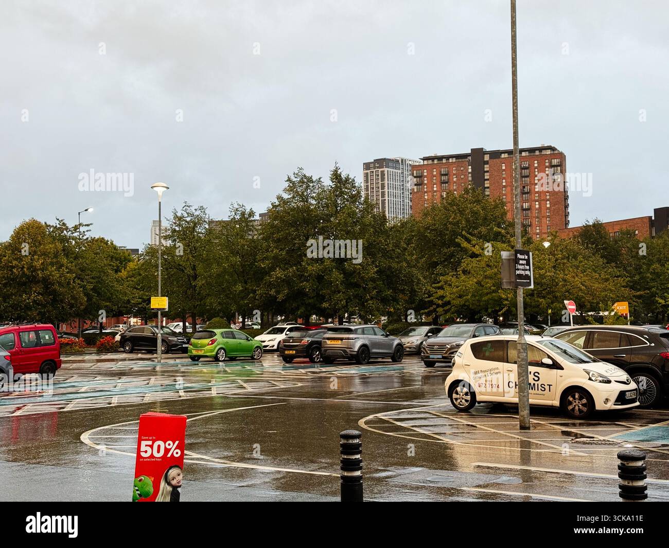 Manchester, UK - September 10, 2025: Vehicles parked in a wet parking ...