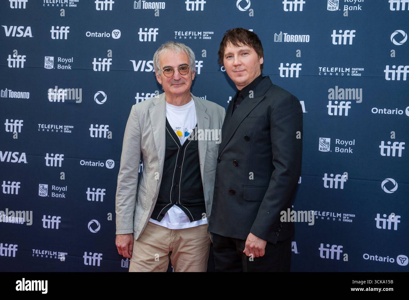 Director Oliver Assayas, left, and Paul Dano arrive on the red carpet ...