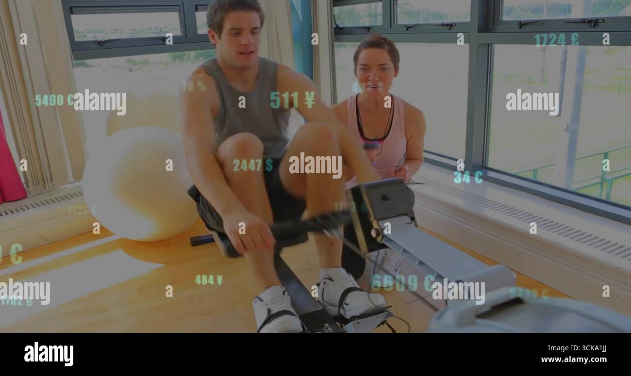 Rowing personal trainer and client on rower in gym wearing sportswear ...