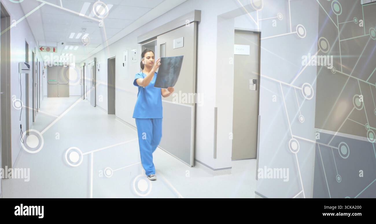 Nurse in blue scrubs holding and inspecting X-ray film in hospital ...