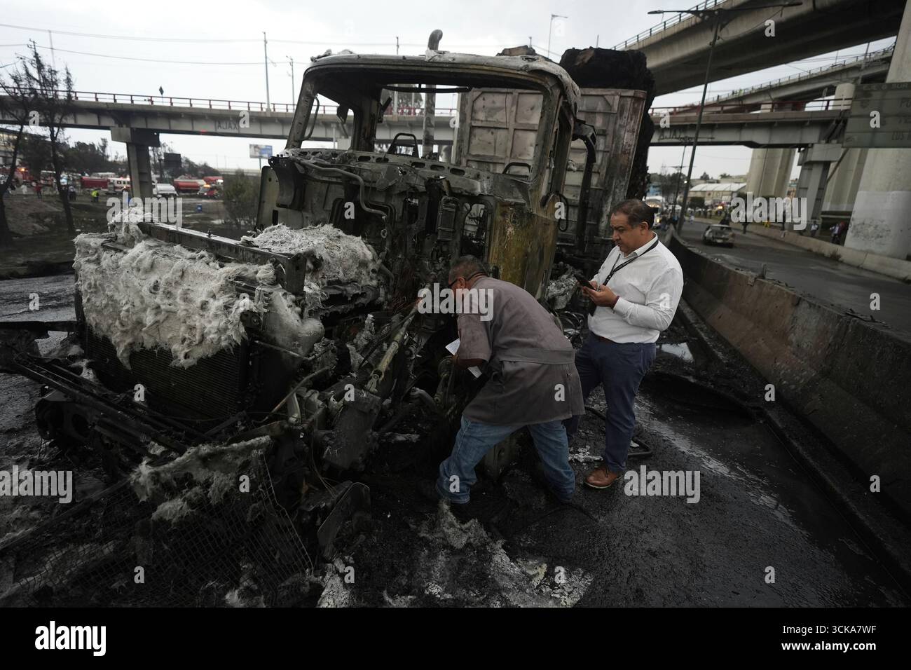 Investigators inspect burned cars after a gas tanker explosion in ...