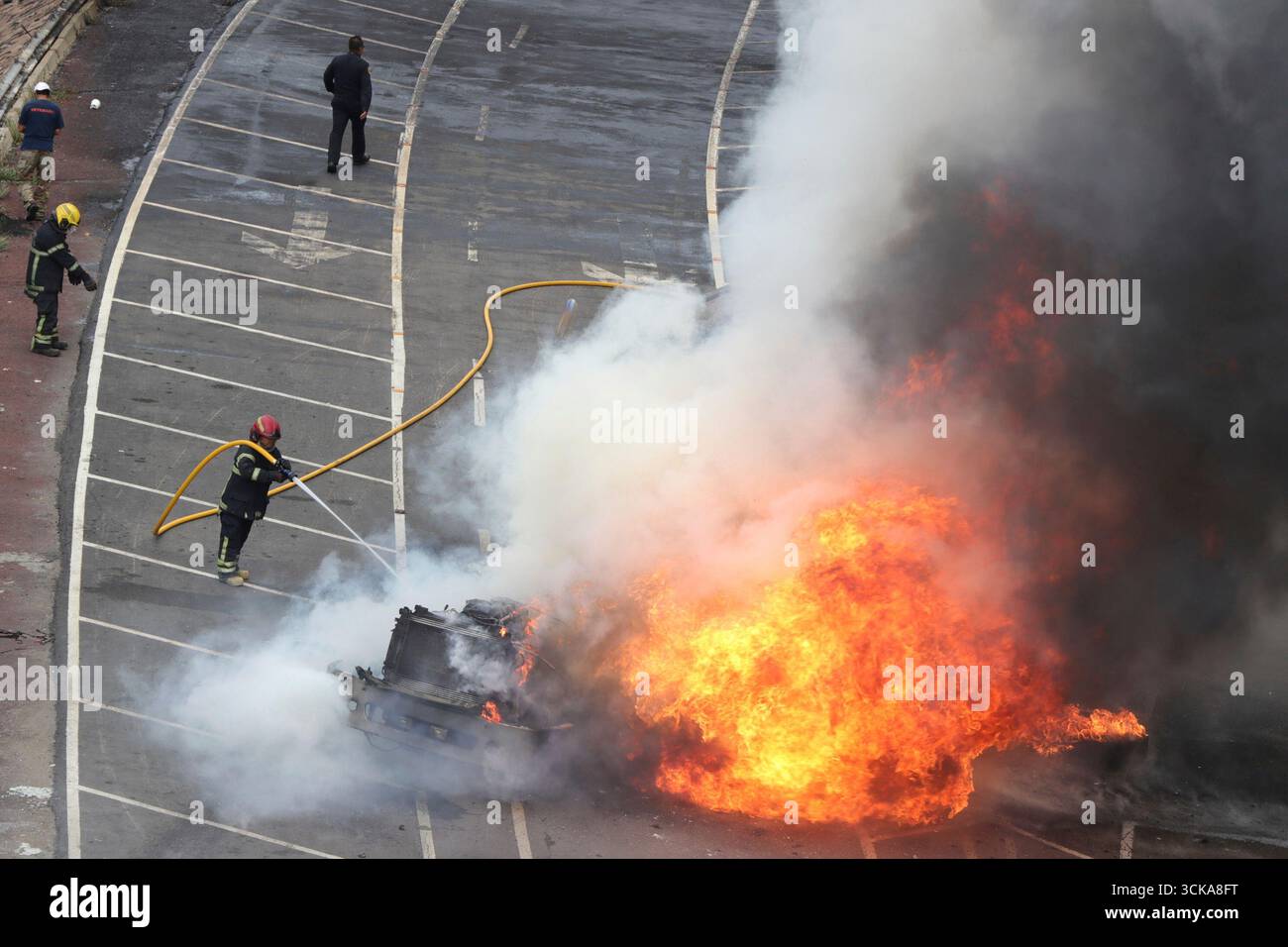 A firefighter extinguishes a fire after a gas tanker exploded under a ...