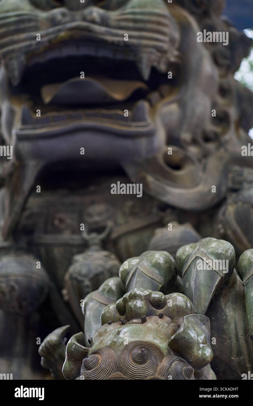 Detailed closeup of an ancient bronze guardian lion cub and playing ...