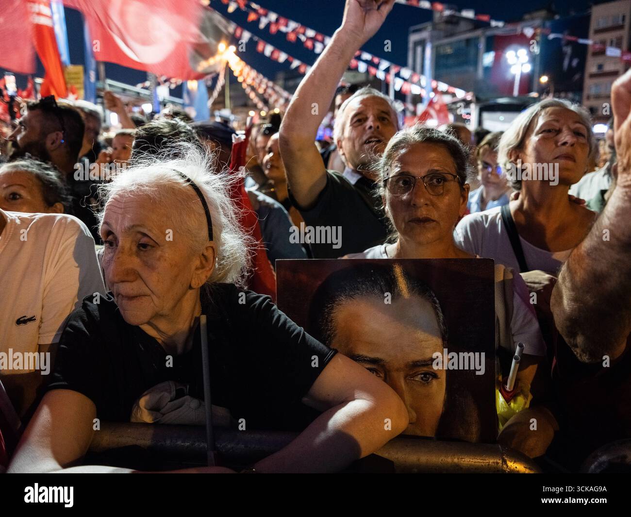 A woman holds a portrait of Mustafa Kemal Ataturk, the founder of the ...