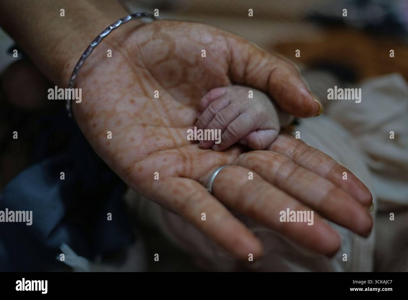 Antima Kumari holds the hand of her newborn nephew at their house in Gurugram, a satellite city ...