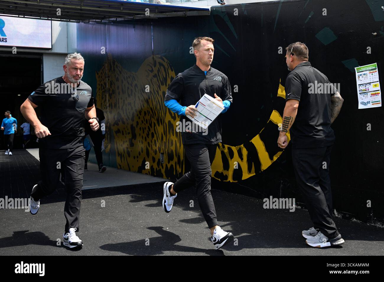 Carolina Panthers offensive coordinator Brad Idzik, center, runs to the ...